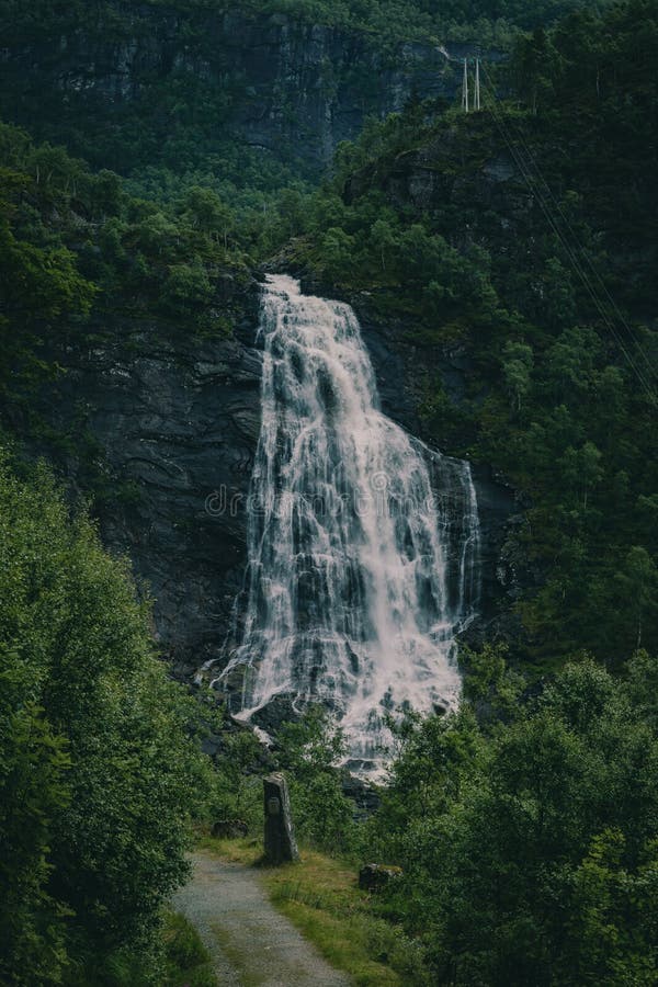 Vertical and Long Exposure Shot of a Waterfall in a Valley Emerging ...