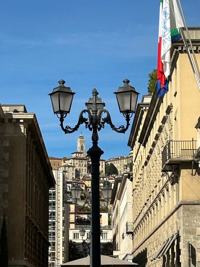 Vertical Low-angle of a Black Street Lamp, Sunlit Buildings Background ...