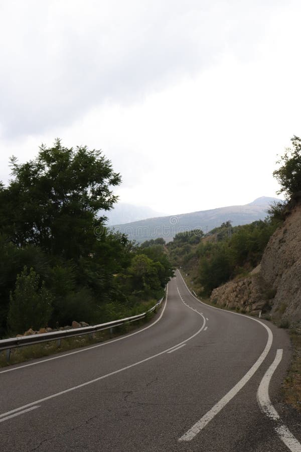 Vertical Low-angle of a Road through Rocky Mountains, Gloomy Sky ...