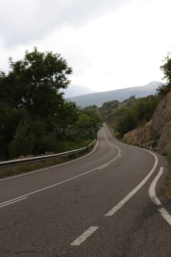 Vertical Low-angle of a Road through Rocky Mountains, Gloomy Sky ...