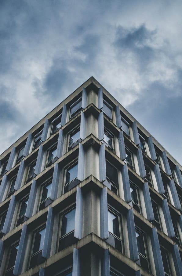 Vertical Low Angle Shot of a Blue and Gray Building Under a Cloudy Sky ...