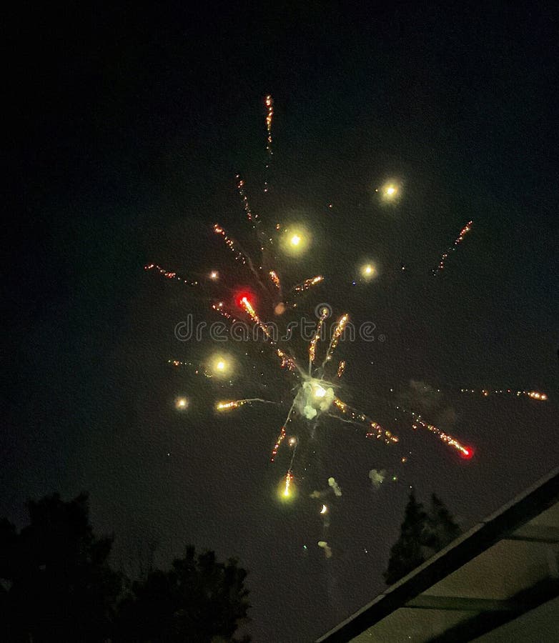 Vertical Low Angle Shot of Glowing Exploding Fireworks in a Dark Sky ...