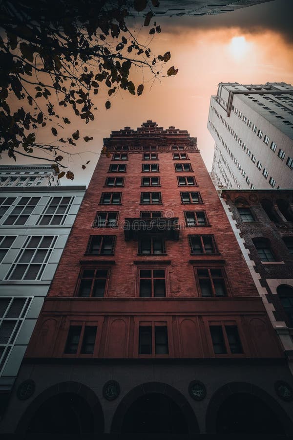 Vertical Low Angle Shot of Red Brick Building between Plain Buildings ...