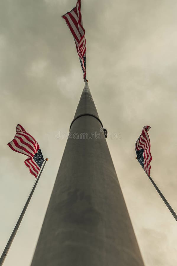 Vertical Low Angle Shot of Three Poles with American Flags Stock Image ...