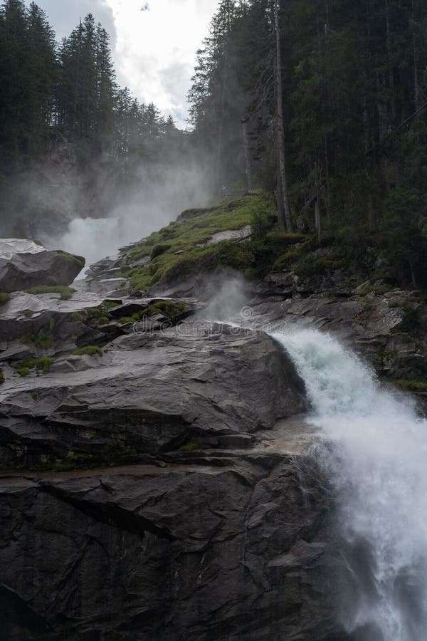 Vertical Low-angle of a Waterfall with Trees and Stone on Both Sides ...