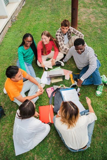Vertical. Multiracial Students Using a Laptop Computert Sitting in a ...