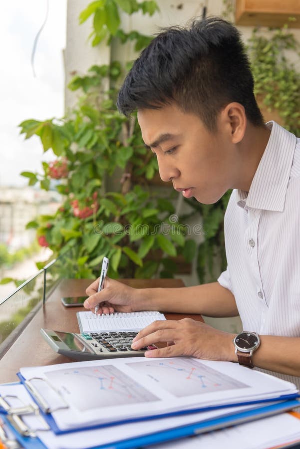 Young Man Doing Calculation on Calculator Stock Image - Image of ...