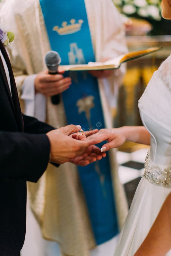 Vertical Photo of the Hands of Groom Putting the Wedding Ring on the ...