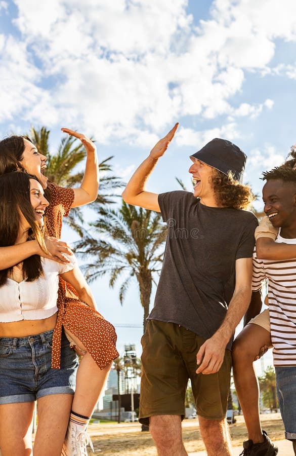 Young Group Of Happy Diverse Friends Laughing While Walking Together