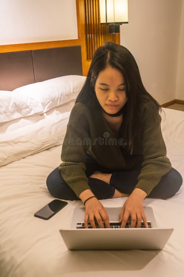 Vertical Photo of Young Woman Using Laptop on the Bed Stock Image ...
