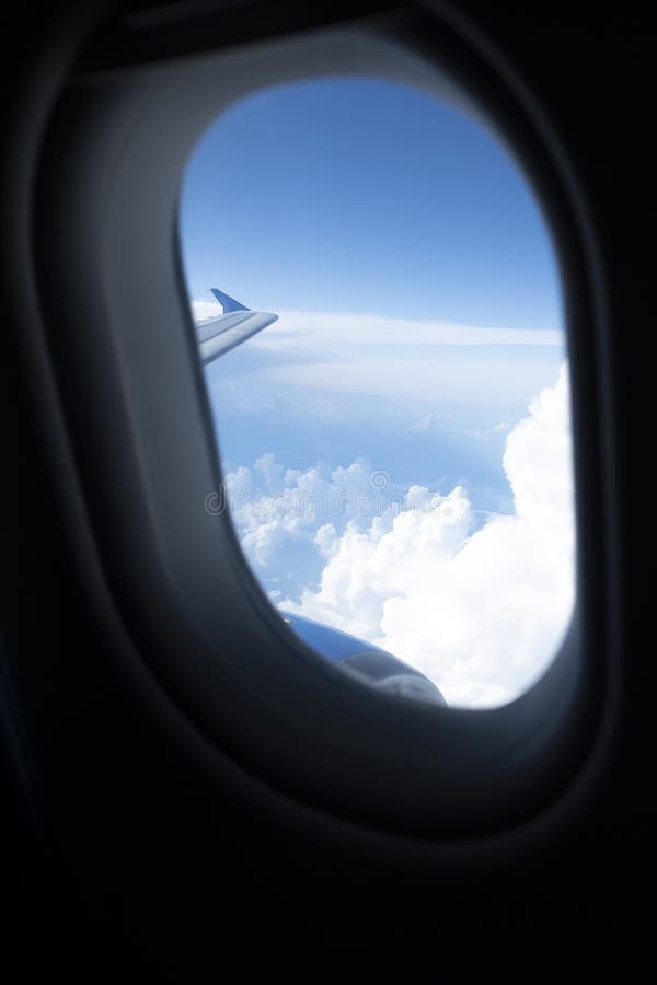 Dark Blue Sky and Clouds and an Airplane Wing and Engine Seen through ...