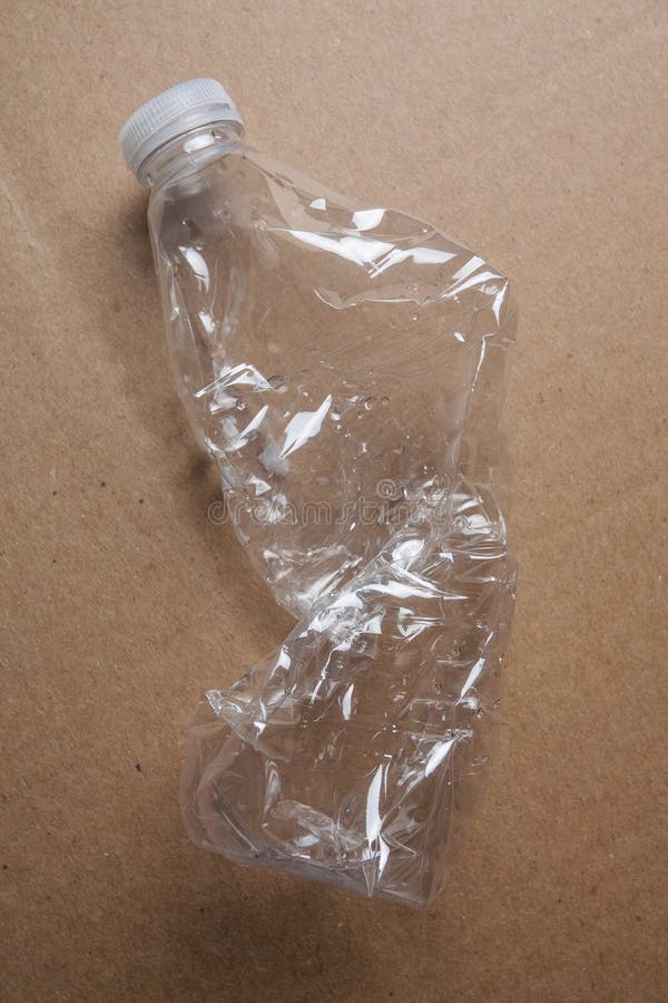 Used Plastic Water Bottle Smashed on a Cardboard Background Stock Image ...