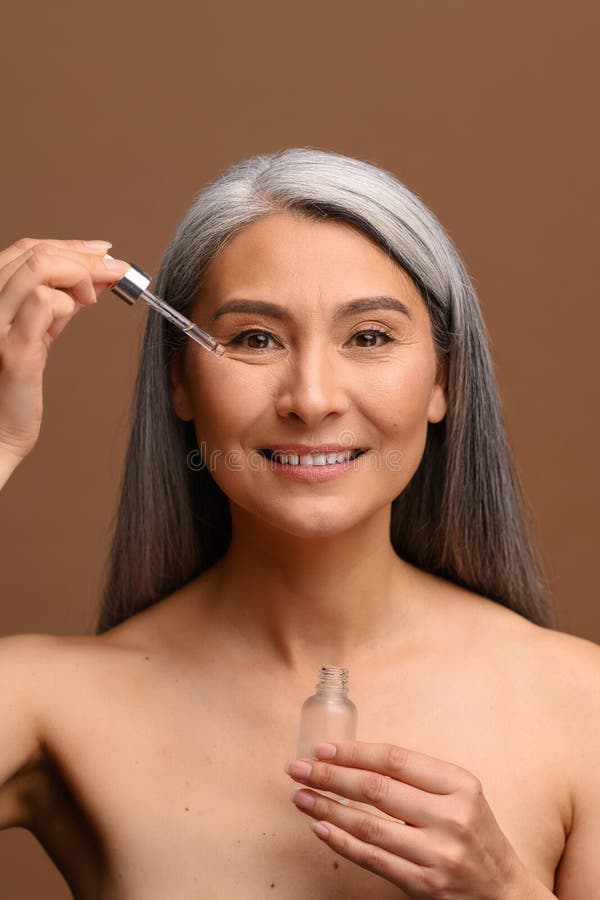 Vertical Portrait Of Smiling Middle Aged Asian Woman With Long Gray