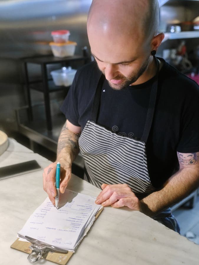 Cook Checking the List of Tasks To Prepare the Tasting Menu in a ...