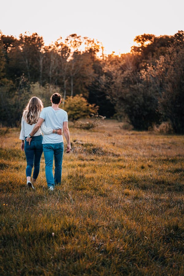 Vertical Rear of a Couple Walking in an Autumn Forest while Cuddling ...
