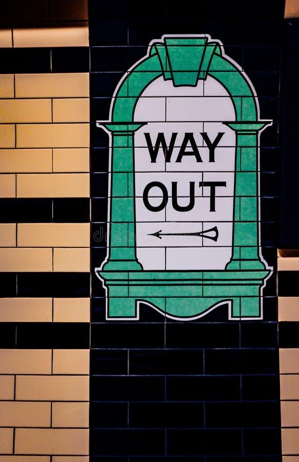 Vertical Rectangular Way Out Sign Against a Brick Wall in a Subway ...