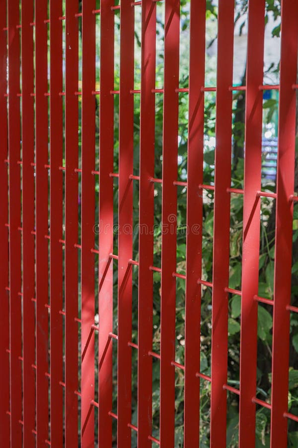 Red Vertical Bars Create a Vibrant Contrast with Green Foliage in ...