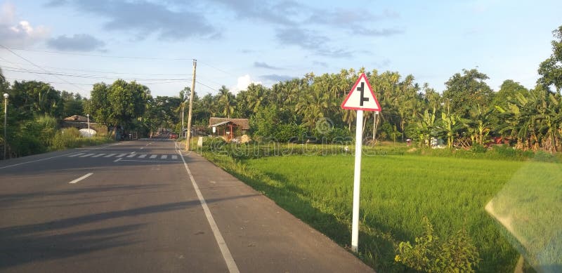 Vertical Road beside Green Field Stock Photo - Image of lighting ...