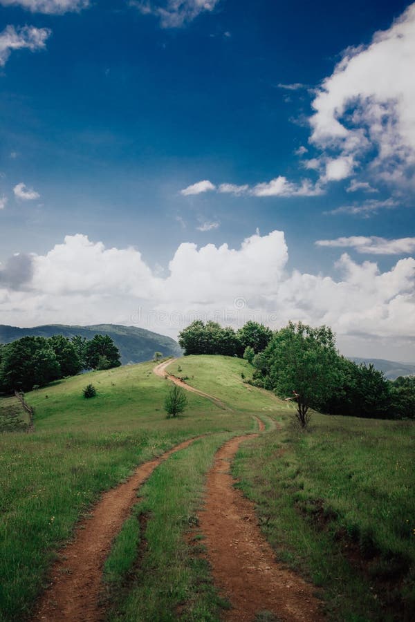 Vertical of a Road in Green Hills in a Countryside on a Sunny Day Stock ...
