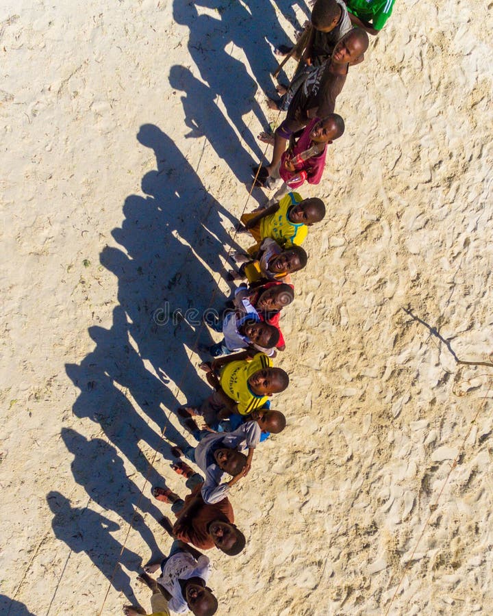 Vertical of a Row of African Kids Standing on Beach and Their Shadows ...