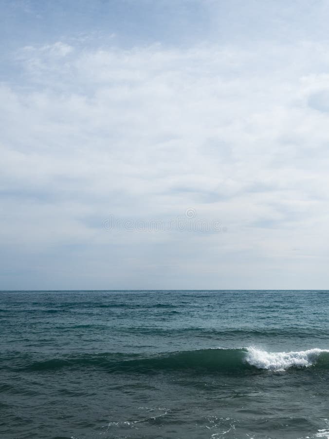 Vertical Seascape View with a Wavy Water Surface Under a Cloudy Sky ...