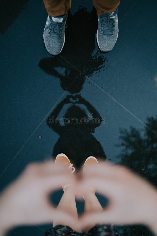 Vertical Selective Overhead Shot of a Reflection of a Couple Showing ...