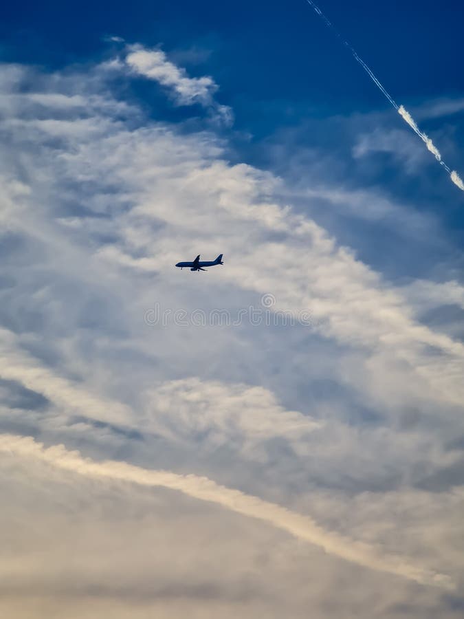 Vertical Shot of an Airplane in Flight in the Sky Full of Clouds Stock ...