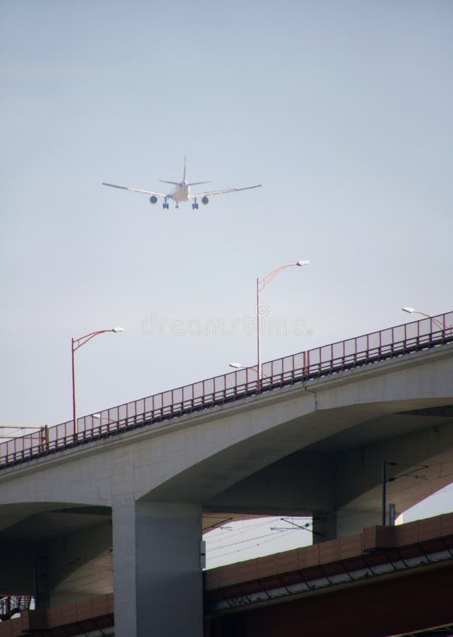 Vertical Shot of an Airplane Flying Over a Bridge Stock Image - Image ...