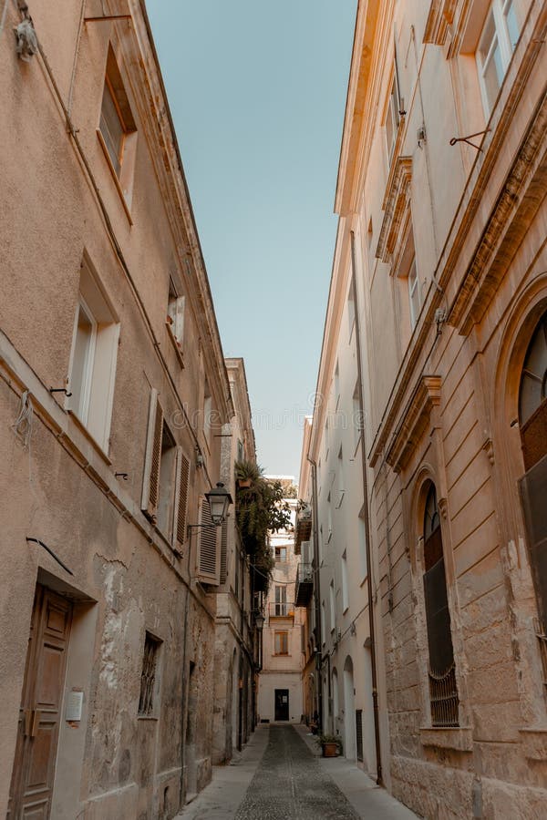 Vertical Shot of an Alleyway in the Middle of Buildings Under a Blue ...