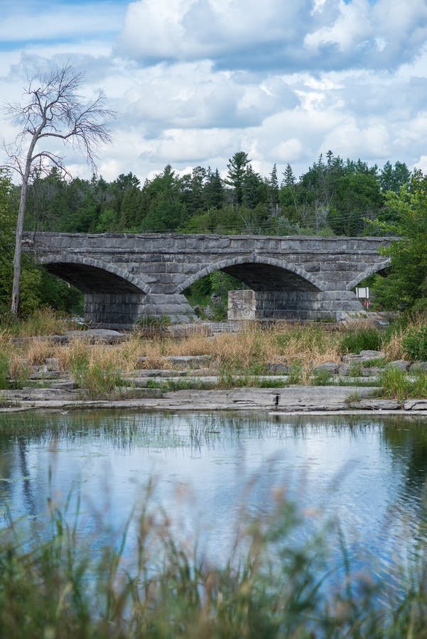 Arched Stone-made Bridge Over a Flowing Stream of Water Surrounded by ...