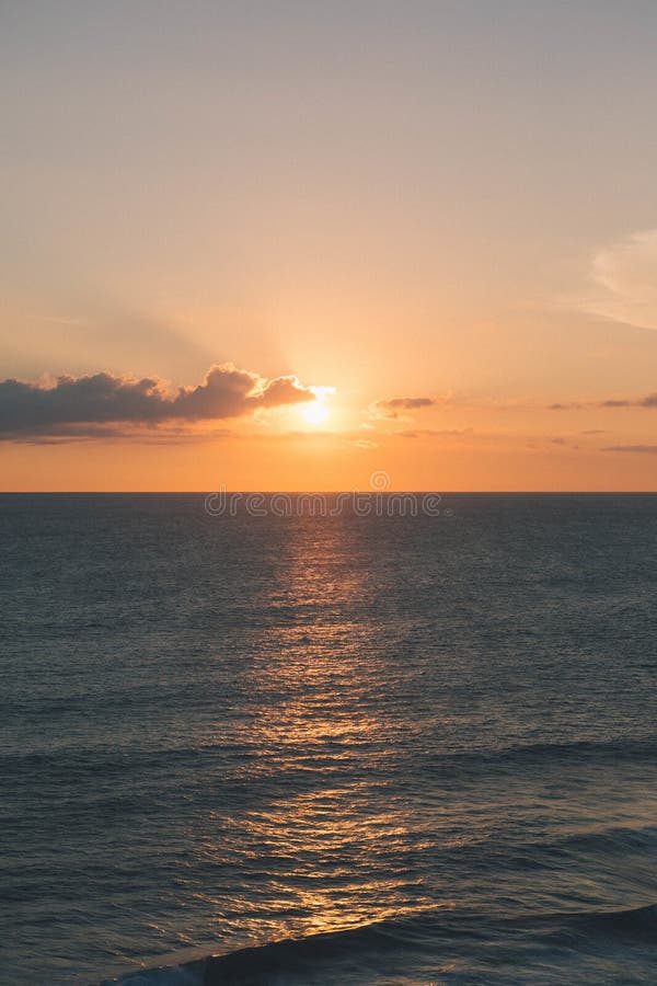 Vertical Shot of Beautiful Scenery of Sunset Over the Ocean with a ...