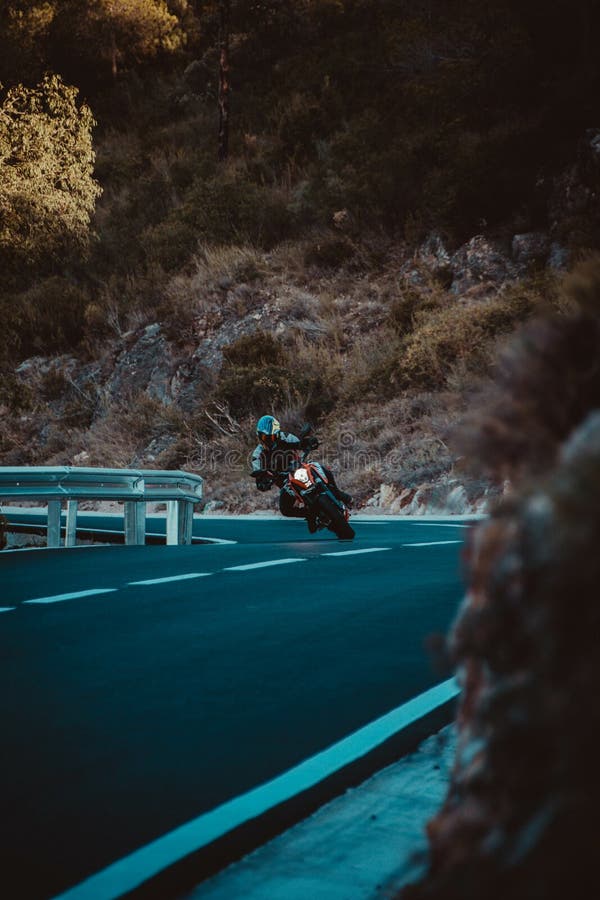 Vertical Shot of a Biker Turning His Motorcycle on the Highway with ...