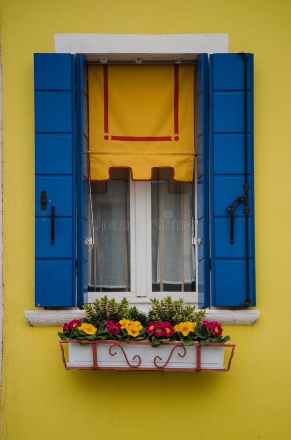 Vertical Shot of a Blue Window on a Yellow Building with Windows on the ...