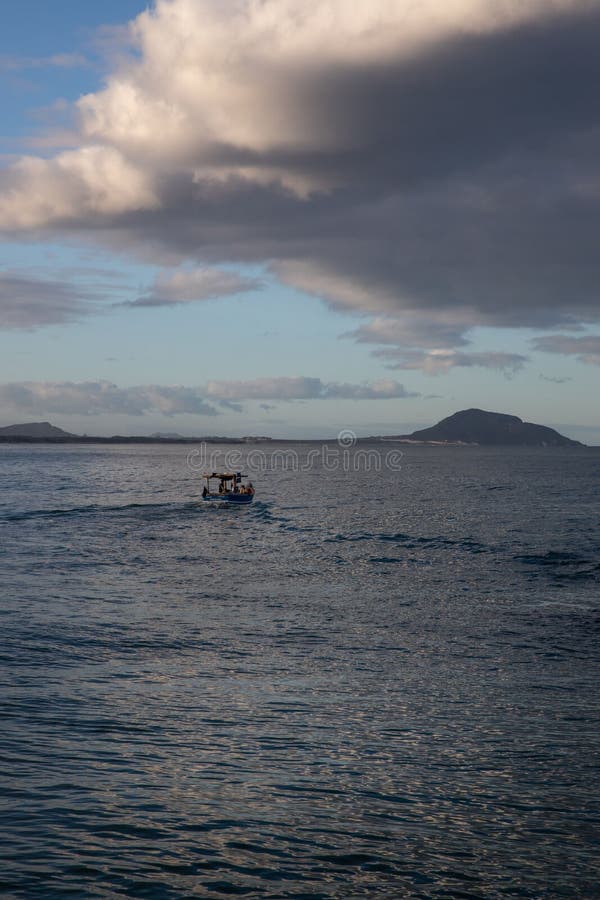 Vertical Shot of a Boat Sailing on the Beach Stock Photo - Image of ...
