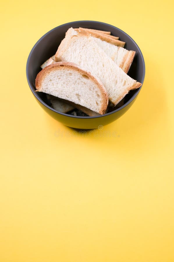 Vertical Shot of Bread Slices on a Bowl Isolated on Yellow Background ...