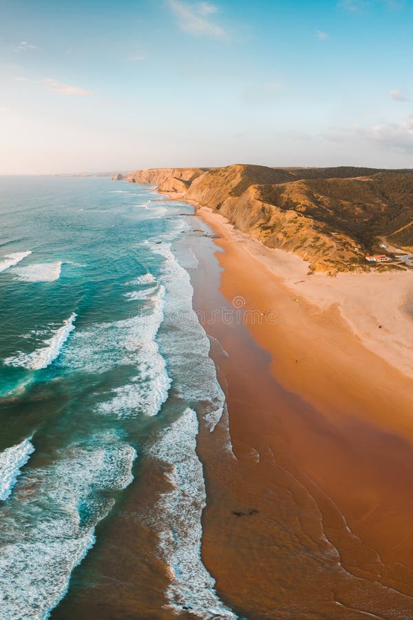 Vertical Shot of the Breathtaking Ocean Waves and the Beach with Rocky ...