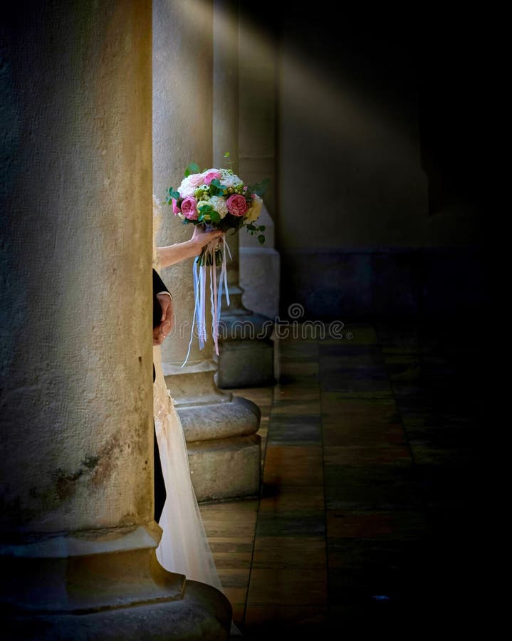 Vertical Shot of the Bride Holding the Wedding Bouquet Behind a Thick ...