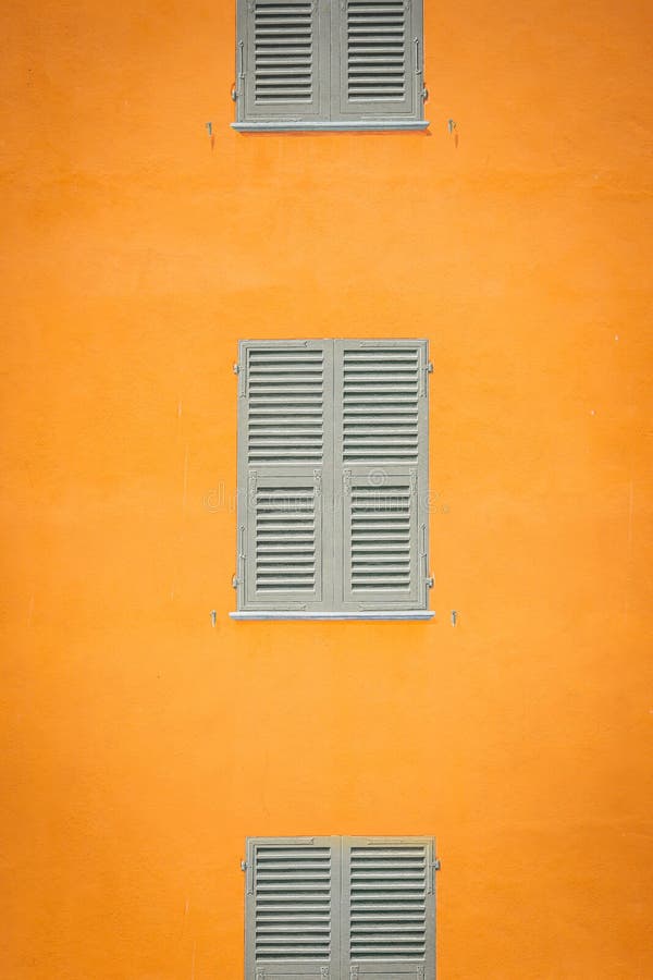 Vertical Shot of the Bright Orange Building Wall with Windows. Stock ...