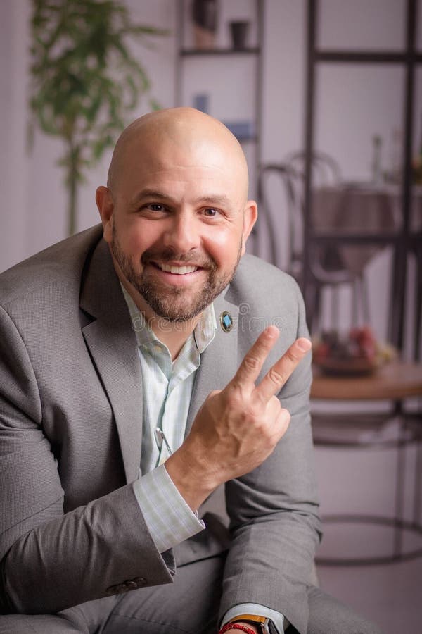 Vertical Shot of a Businessman Showing Peace Sign and Smiling Stock ...