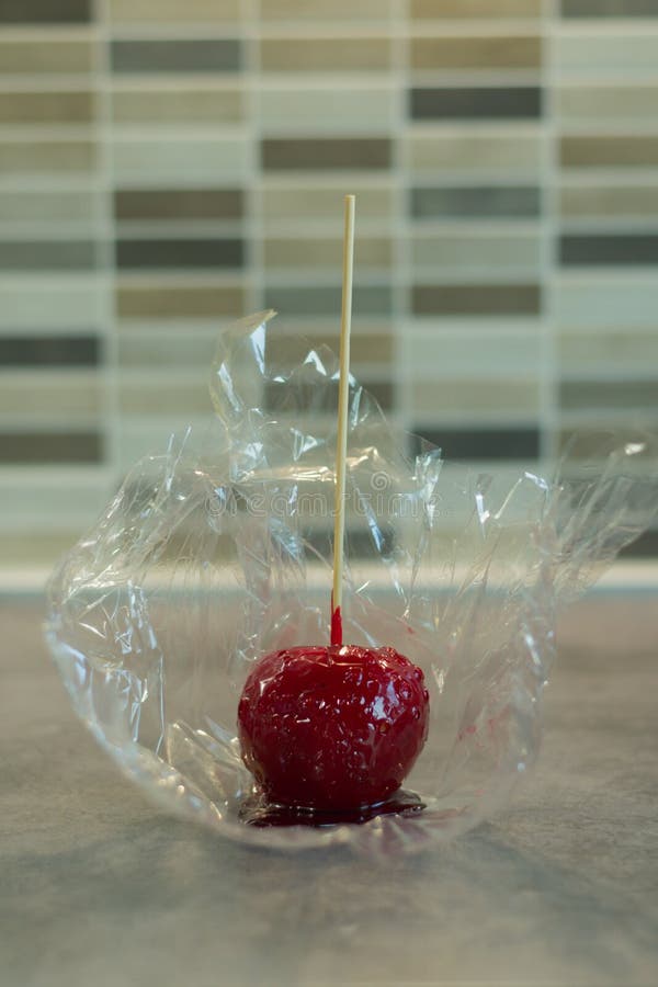Vertical Shot of a Candy Apple on a Stick in Plastic Wrap Stock Image ...