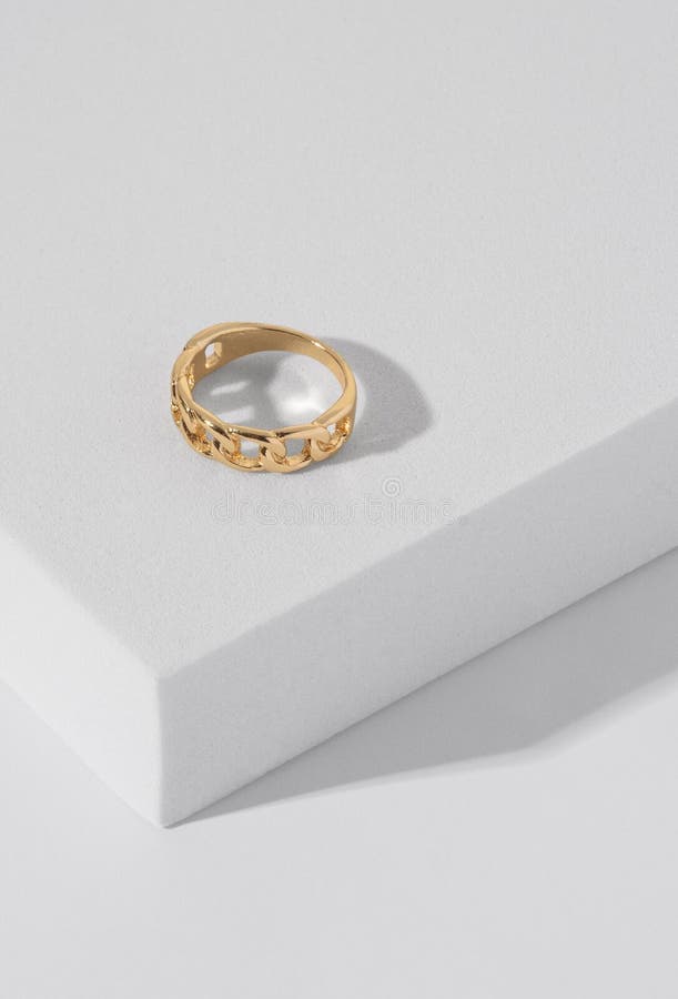 Vertical Shot of Chain Shape Golden Ring on White Podium with Copy ...