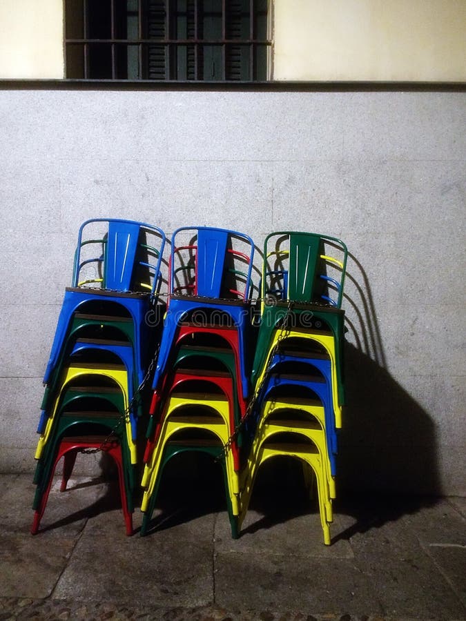Vertical Shot of Chairs of Multiple Colors Stacked on Top of Each Other ...