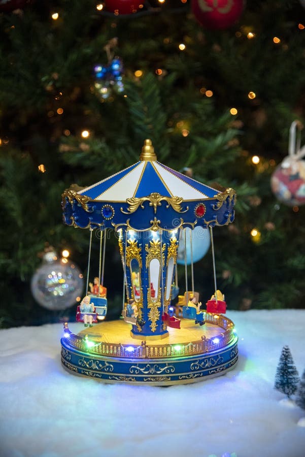 Vertical Shot of a Child Carousel Ornament with the Decorated Christmas ...