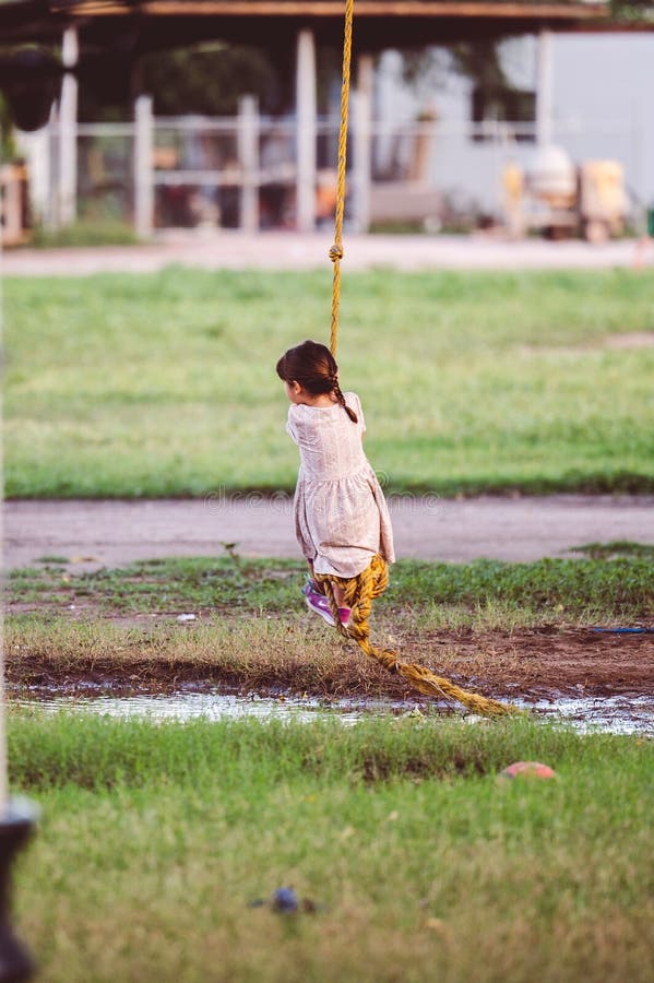Vertical Shot of a Child Son a Rope Swing Stock Photo - Image of rope ...