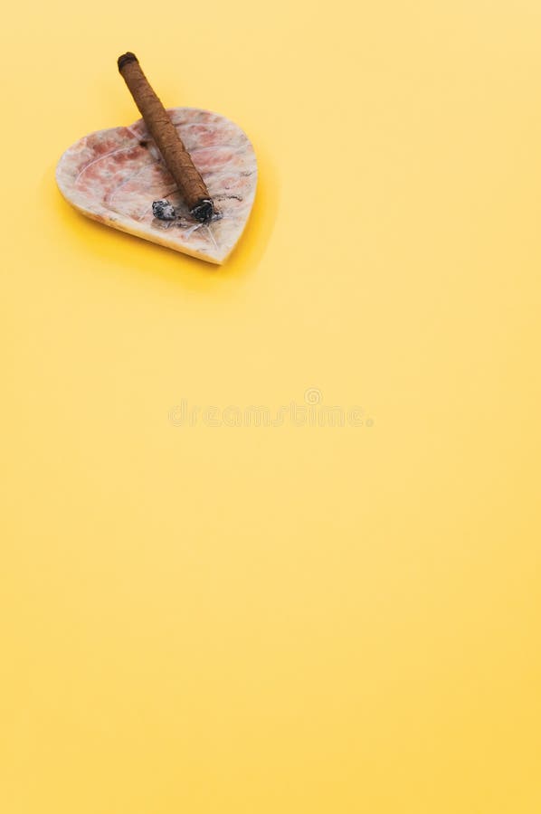 Vertical Shot of a Cigar on an Ashtray on a Yellow Surface Stock Photo ...