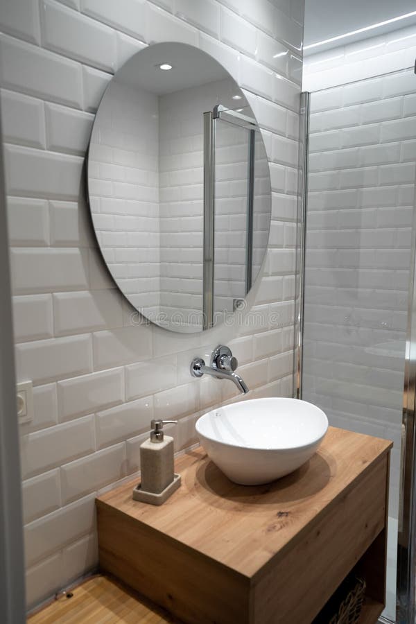 Vertical Shot of Circle Mirror on White Wall with Sink and Water Tap ...