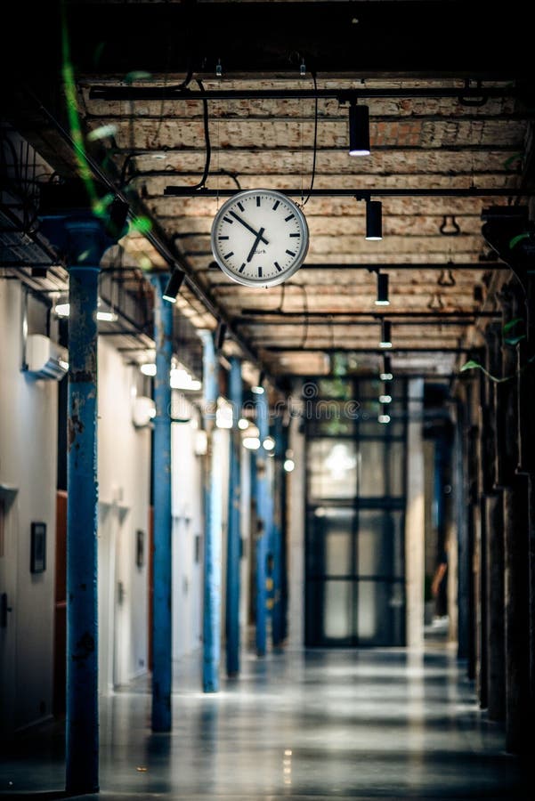 Vertical Shot of a Clock Hanging Inside an Empty Building Stock Image ...