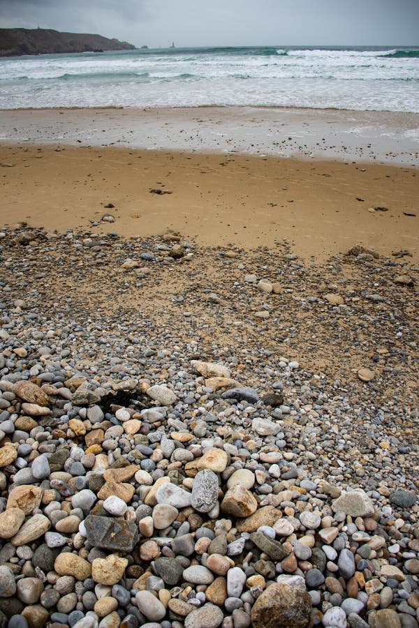 Vertical Shot of a Coast during a Foamy Tide with Pebbles on the Sand ...