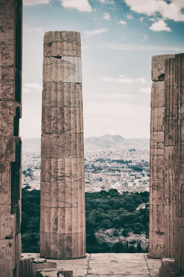 Vertical Shot of Column Ruins on the Background of a Cityscape Stock ...