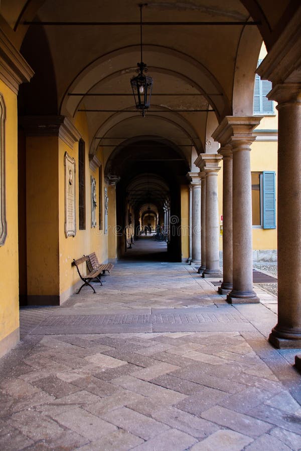 Vertical Shot of a Corridor with Benches, Light Lantern and Pillars in ...